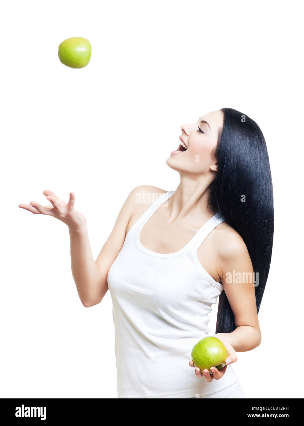happy woman throws up apple on white background Stock Photo - Alamy