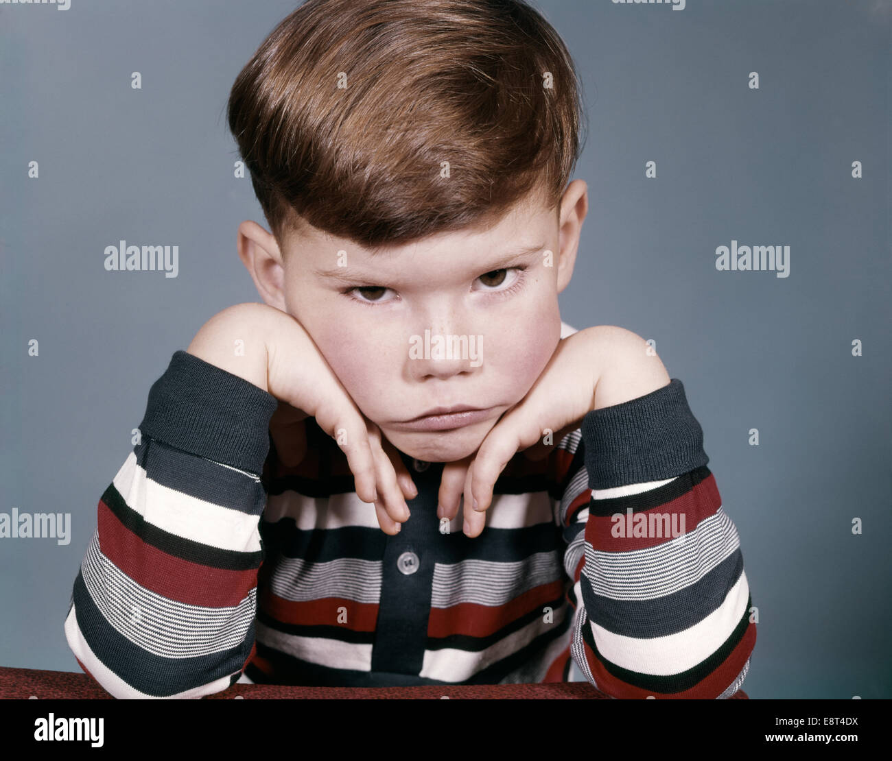 1960s PORTRAIT SAD ANGRY LITTLE BOY STRIPED SHIRT FACE RESTING IN HIS ...