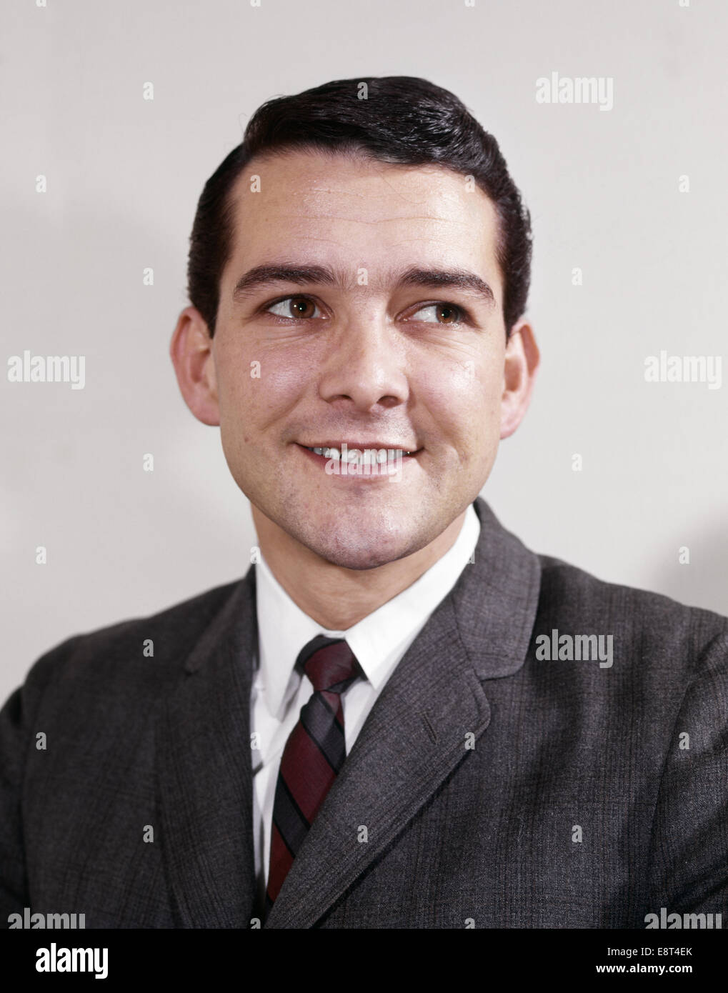 1960s PORTRAIT SMILING YOUNG MAN WEARING SUIT AND TIE LOOKING TO SIDE ...