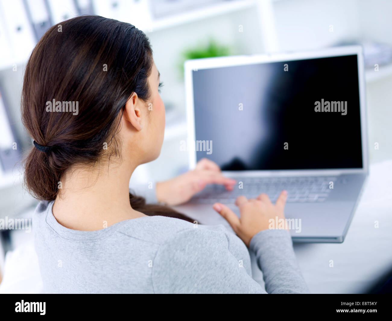 Back view of woman on her laptop Stock Photo - Alamy