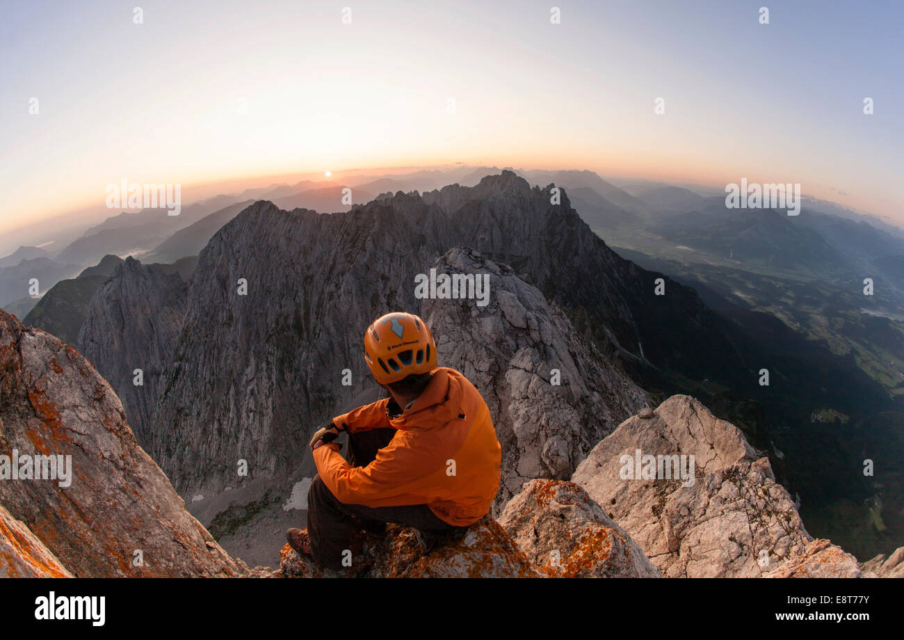 Climber sitting on the top of Ellmauer Halt at sunrise, Ellmau, Wilder ...