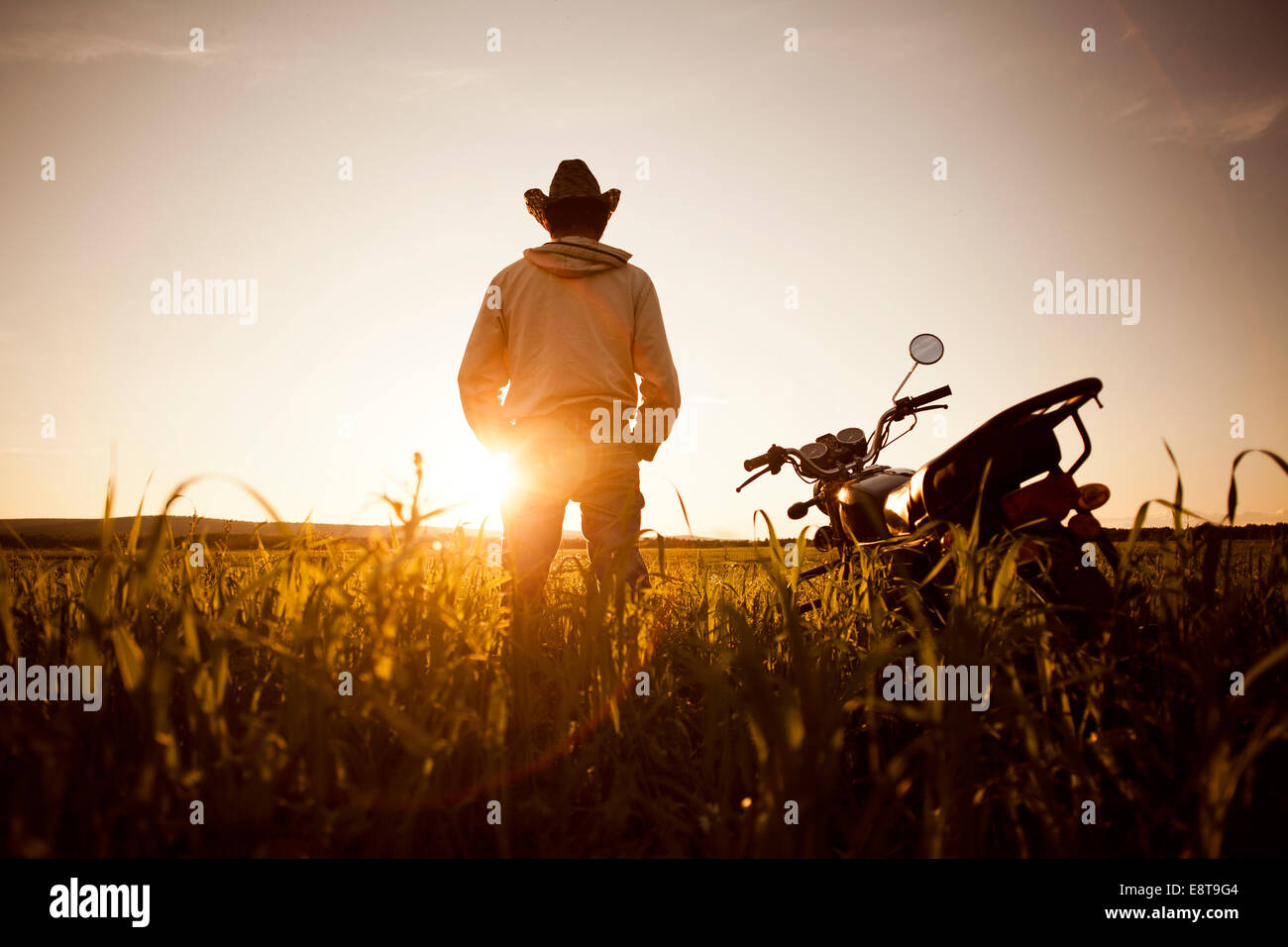 Mari man standing in field with motorcycle Stock Photo - Alamy