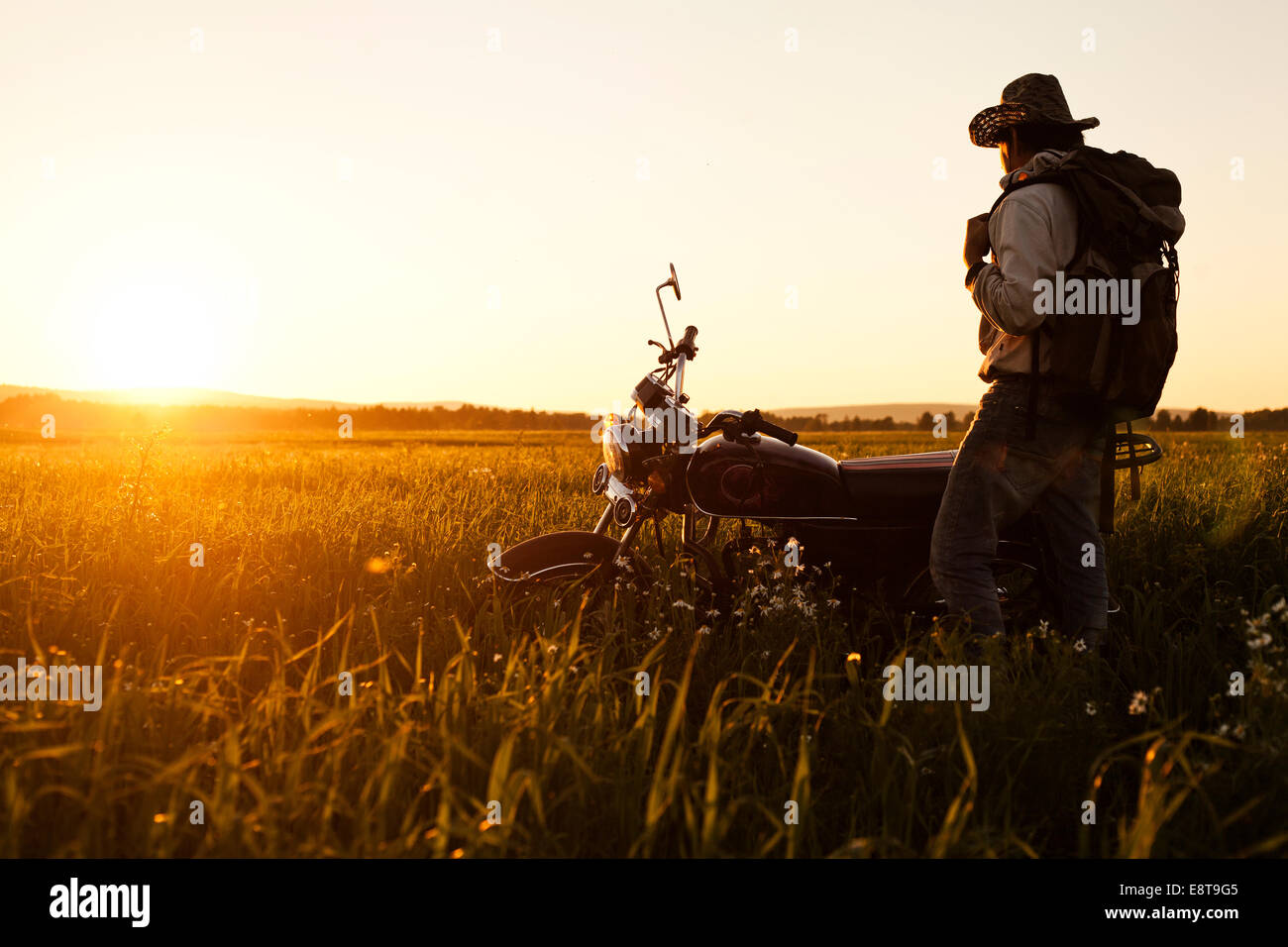 Mari man standing in field with motorcycle Stock Photo - Alamy