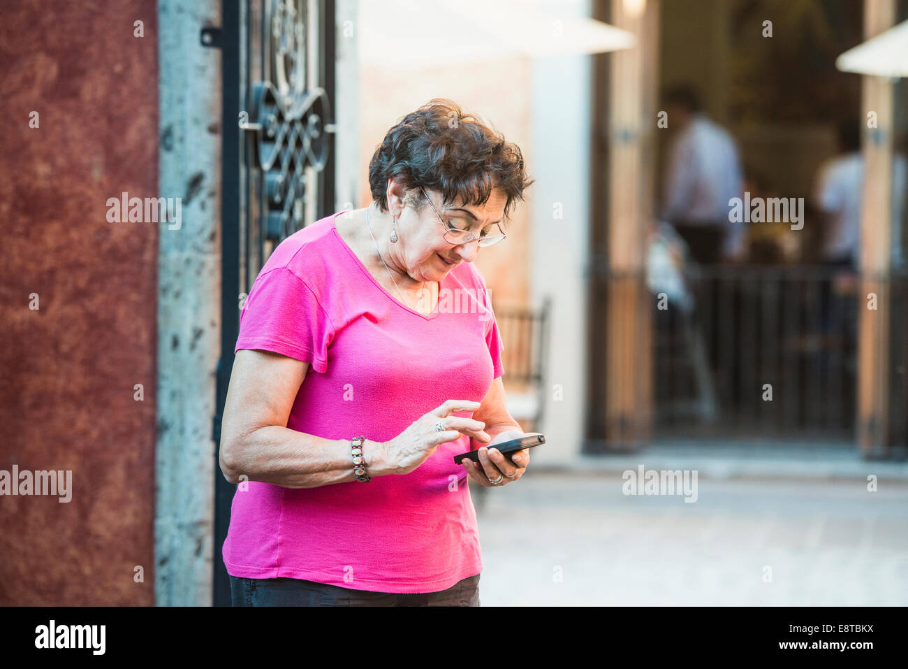 Older woman using cell phone in city Stock Photo - Alamy