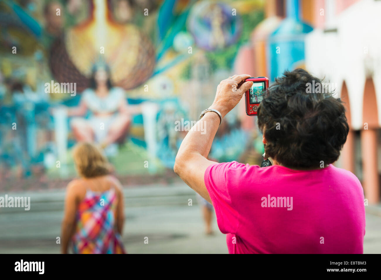 Older woman photographing urban mural Stock Photo - Alamy