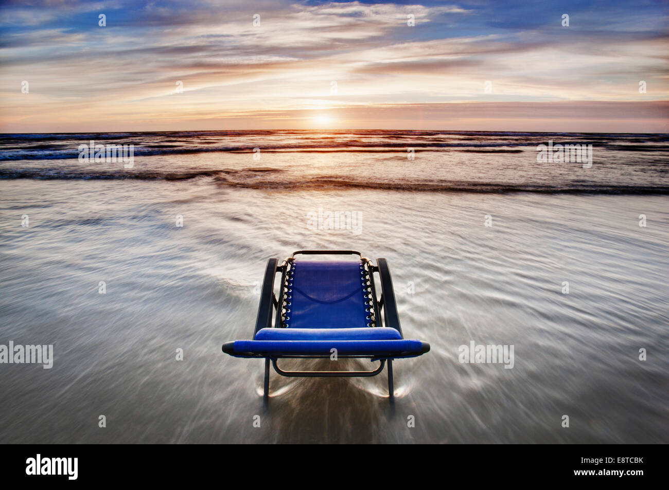 Deck chair overlooking sunset on beach Stock Photo - Alamy