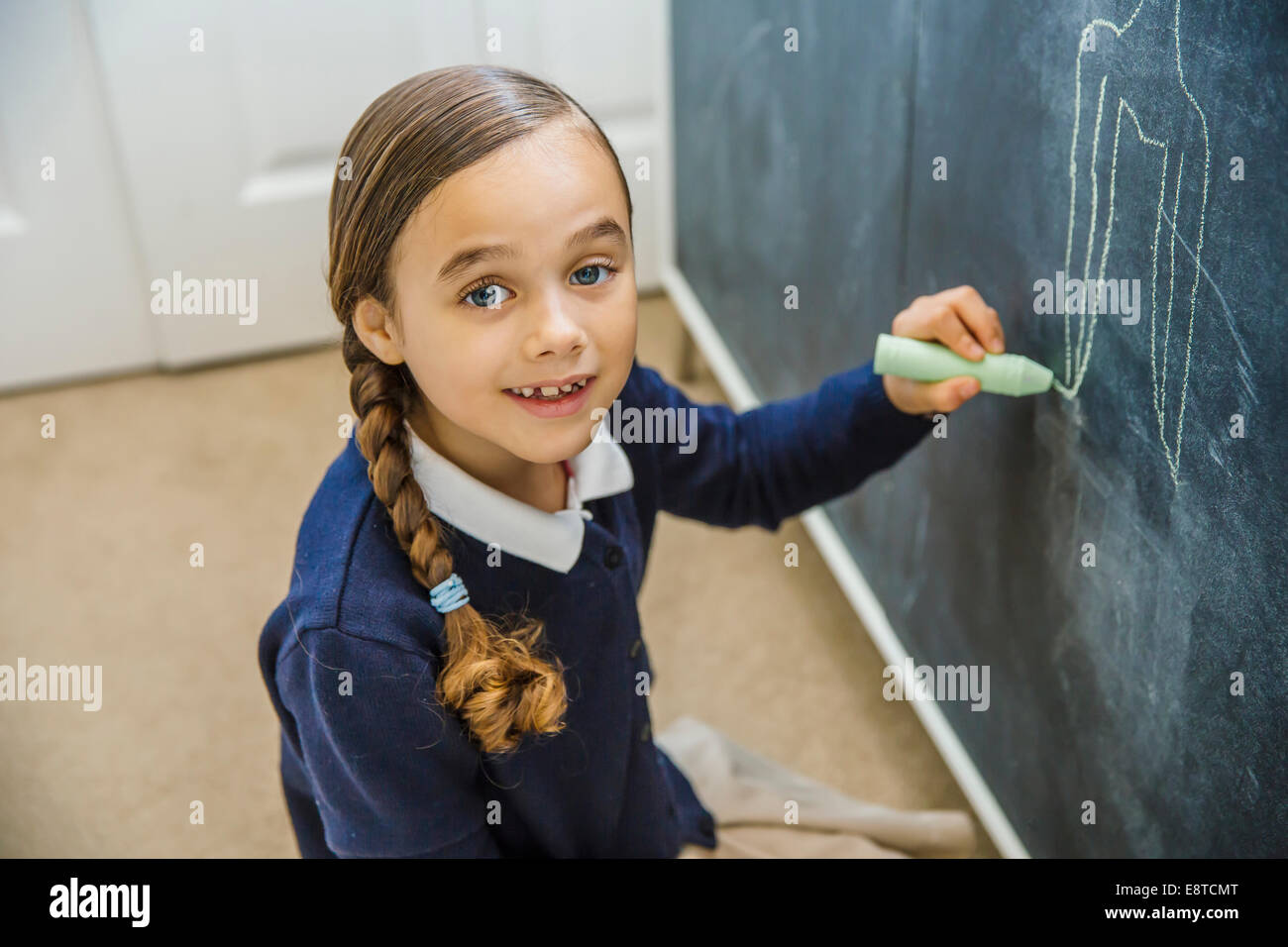 Mixed race girl drawing on chalkboard Stock Photo - Alamy