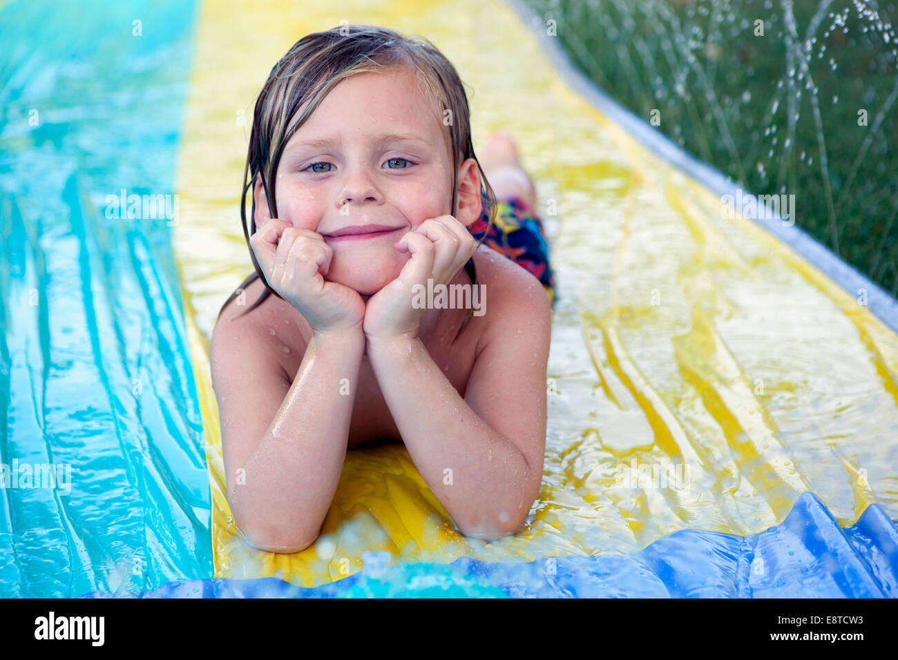 Caucasian boy smiling on water slide Stock Photo - Alamy