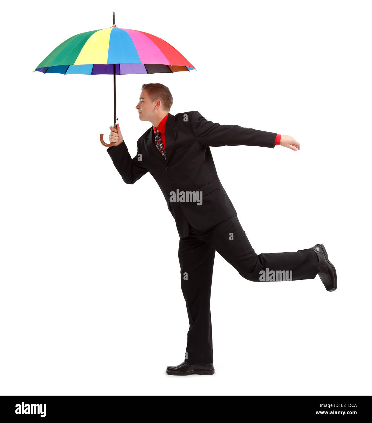 Young man standing on one foot, with big, open, colorful umbrella Stock ...