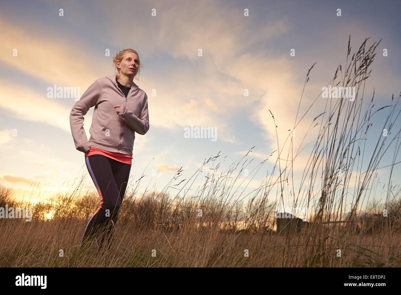 Woman running in a field Stock Photo - Alamy