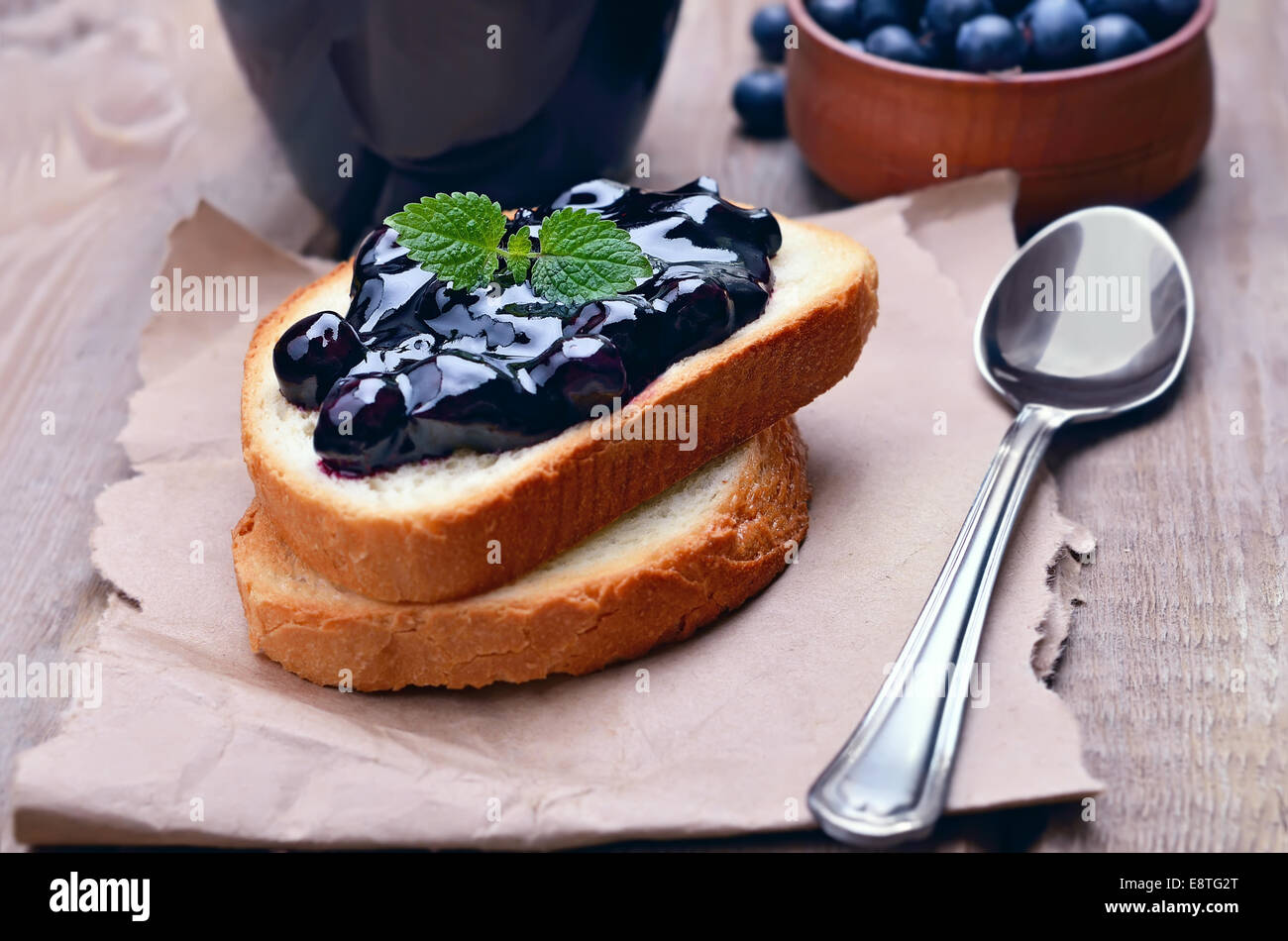 Toasted bread with blueberry jam on wooden table Stock Photo - Alamy