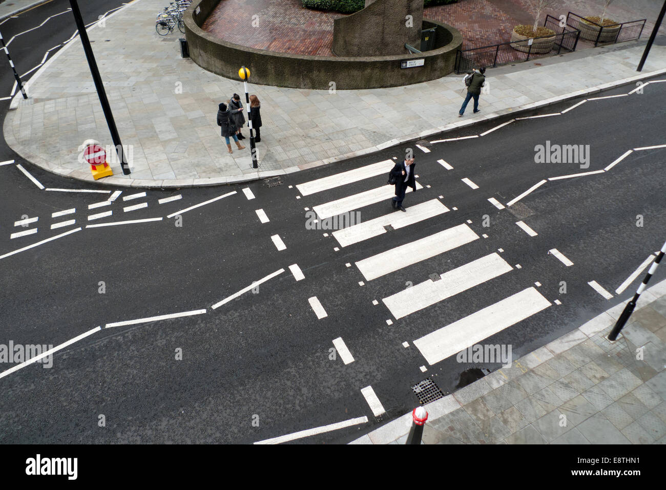 View overhead of a pedestrian crossing the street on white striped road ...