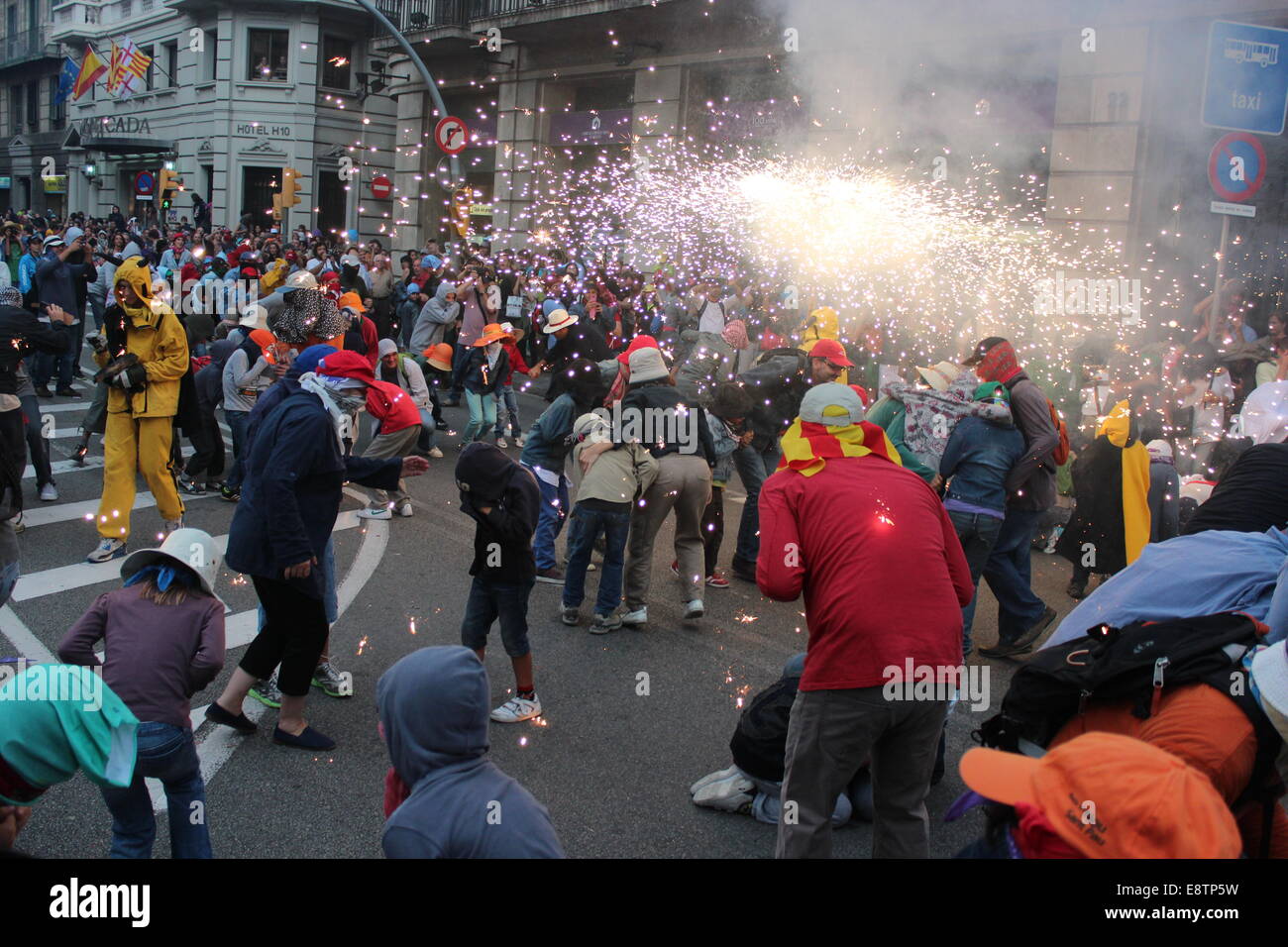 Barcelona, Spain - September 23, 2012: Revelers take cover from sparks ...