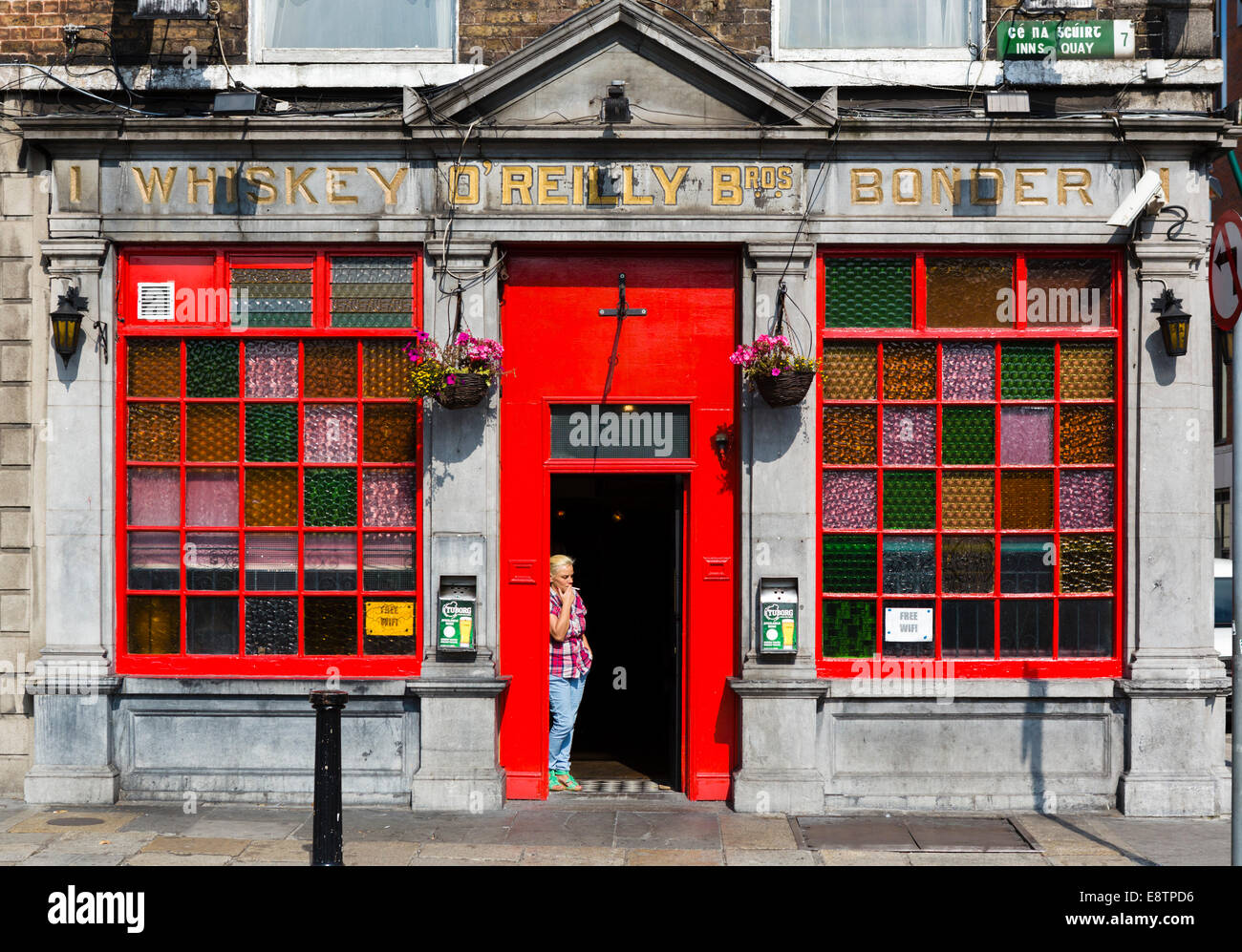 Woman smoking a cigarette in the doorway of a traditional pub on Inns ...
