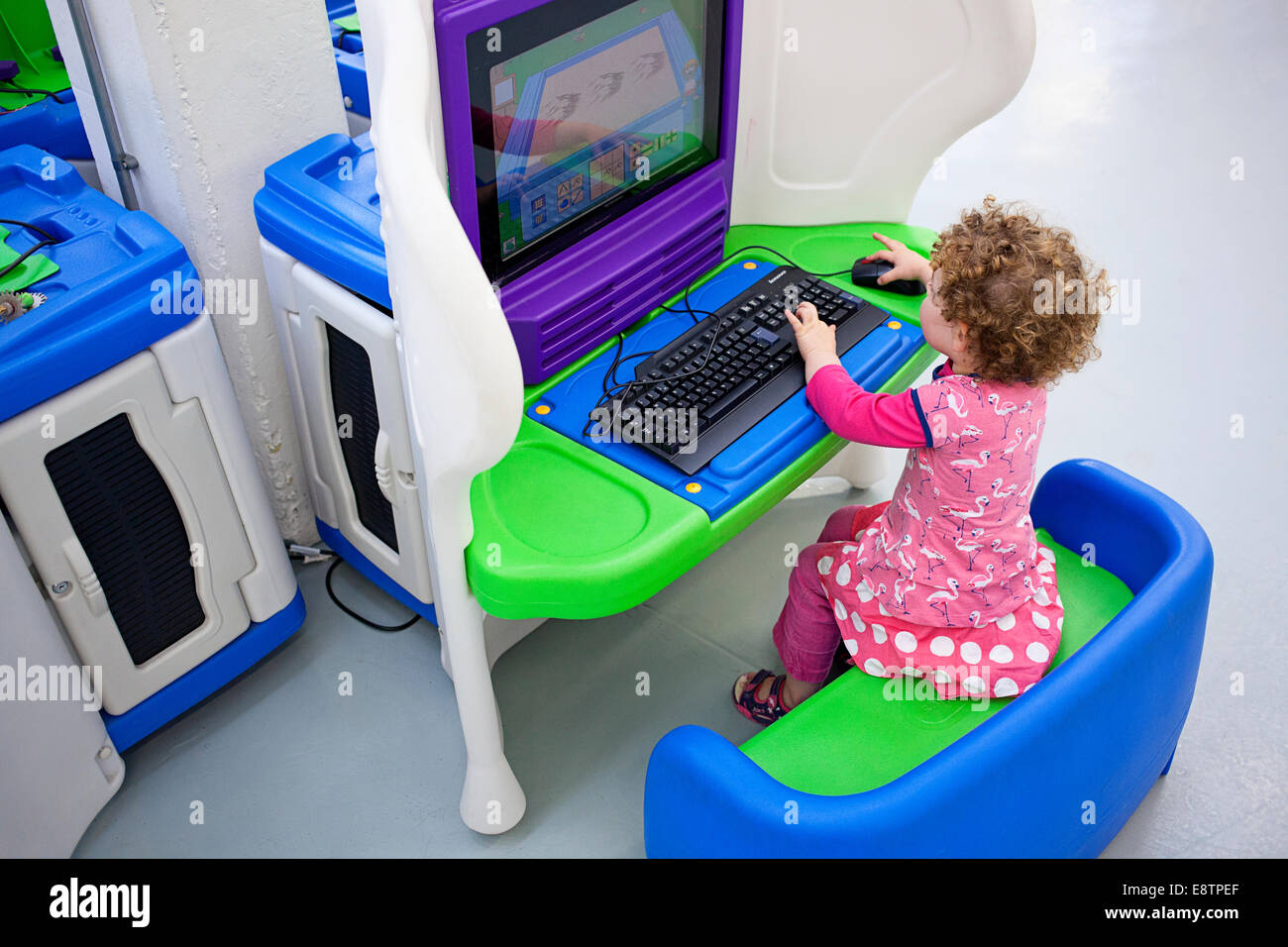 Small child playing with a computer at a science centre Stock Photo - Alamy