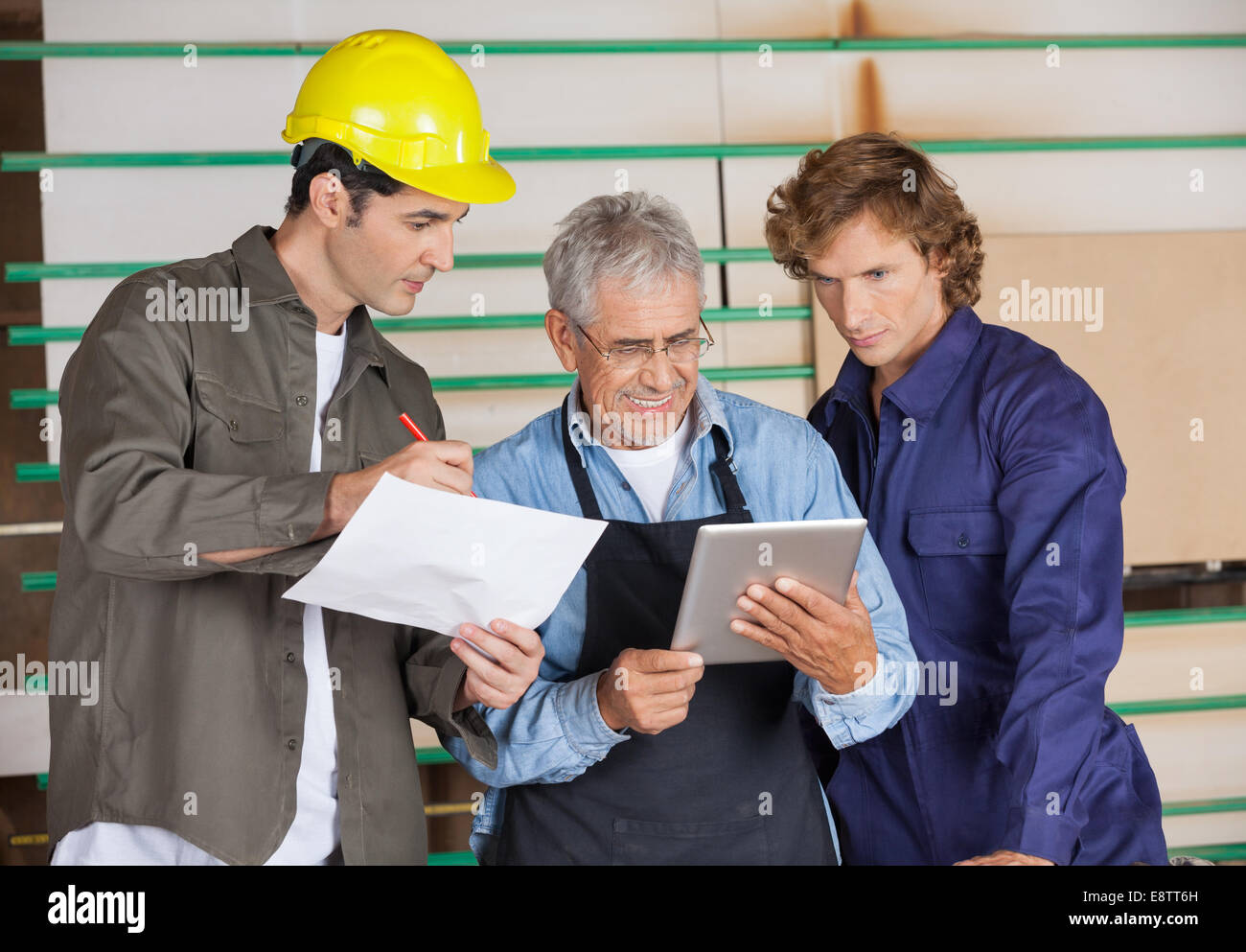Carpenter Holding Tablet Computer While Communicating With Colle Stock ...