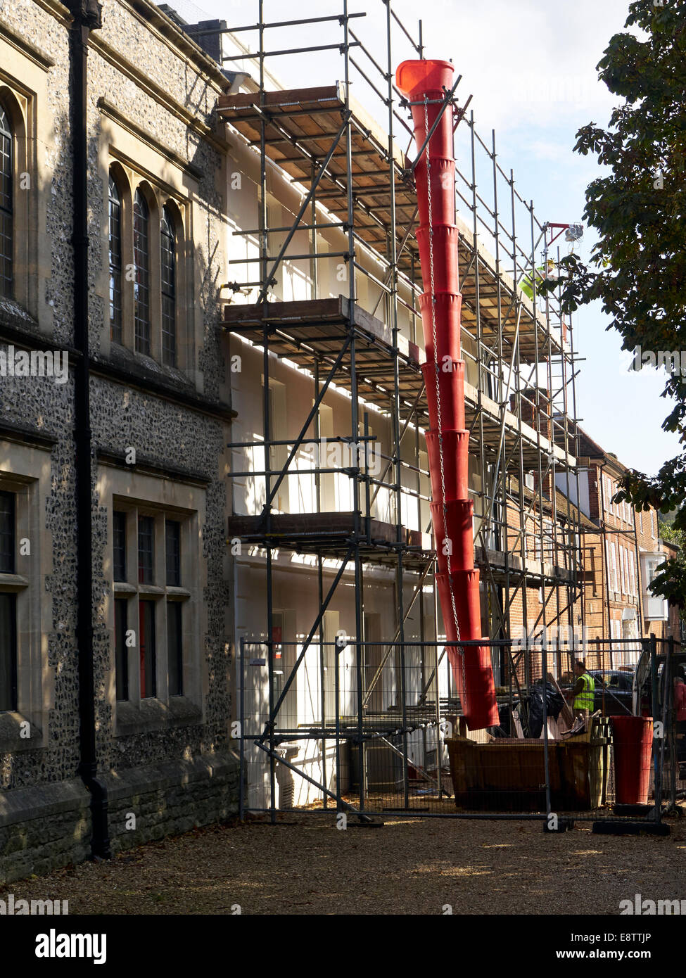 Scaffolding around a Georgian building with a builders chute in use to ...