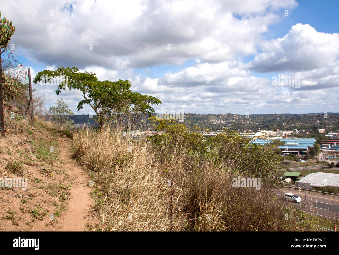 Well worn pedestrian path with industrial area in background under ...