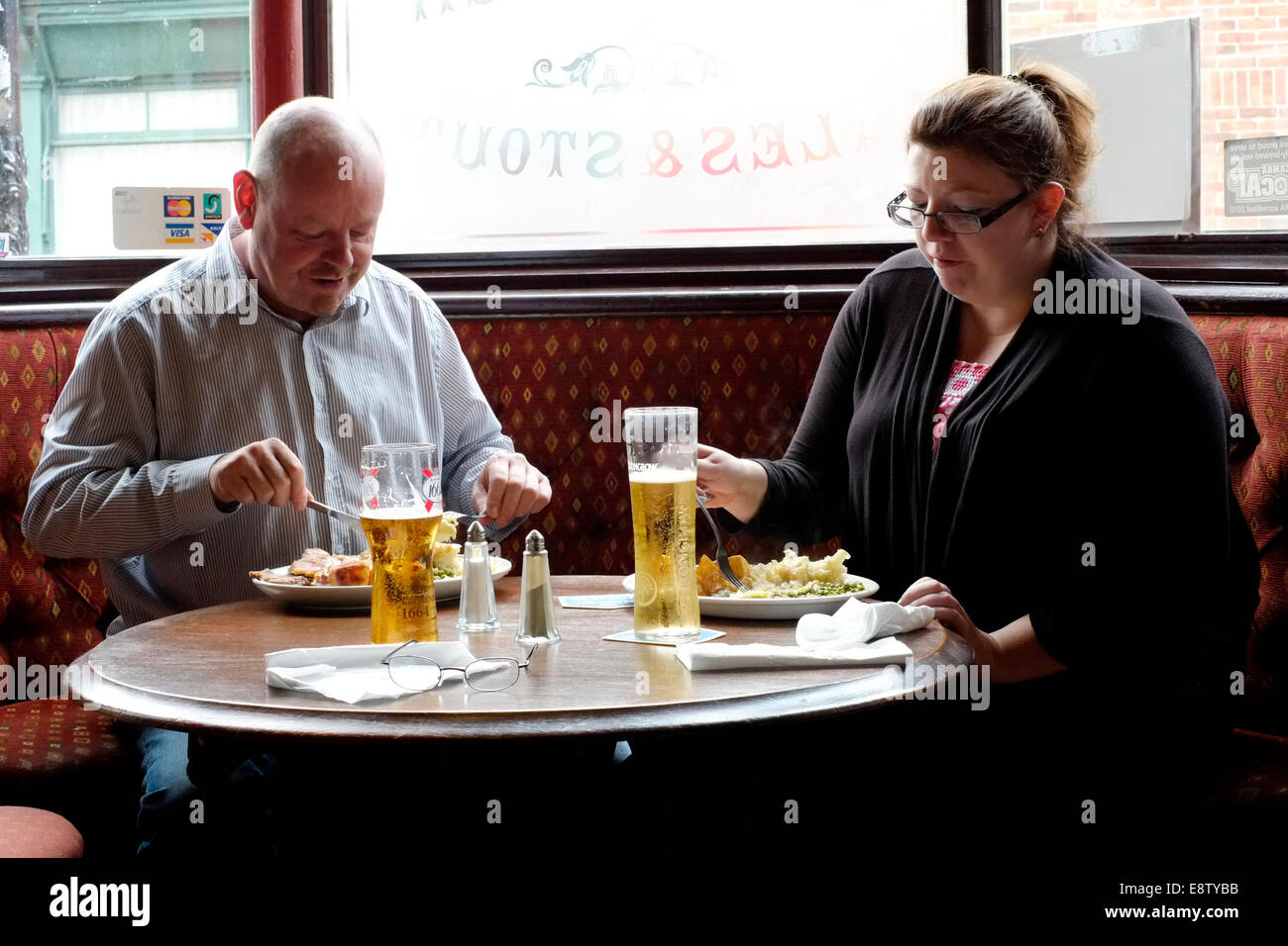 a couple enjoying a sunday roast dinner in a traditional british pub ...
