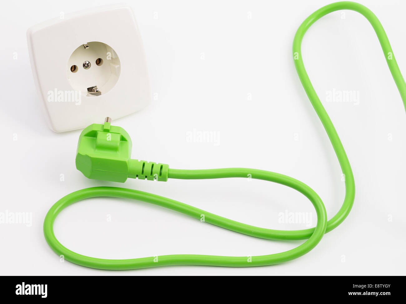Green power plug into power outlet against a white background Stock ...