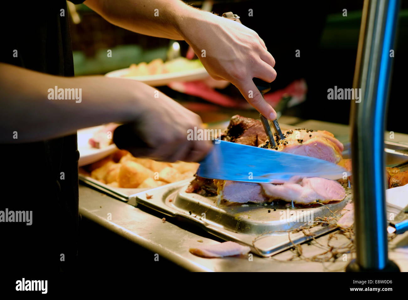 chef carving a gammon joint for sunday lunch carvery at a traditional ...