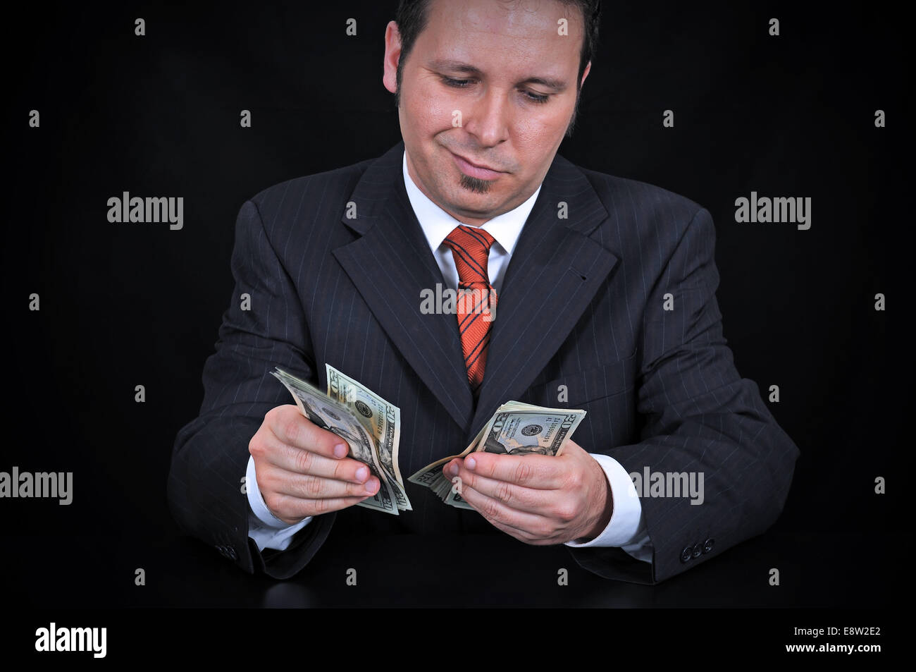 Businessman counting money on the black background Stock Photo - Alamy
