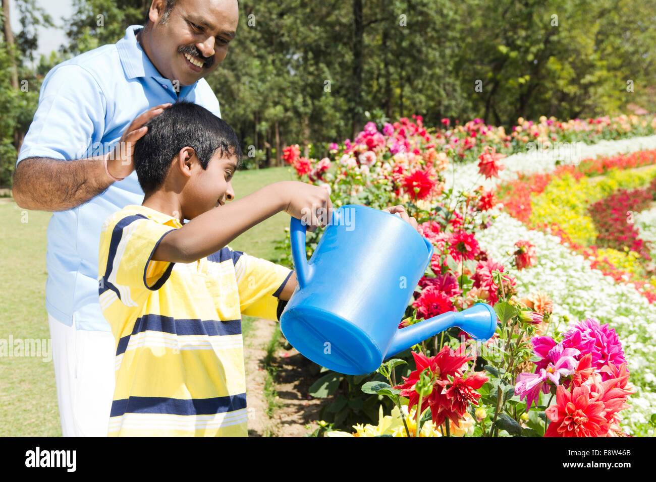 1 Indian Man Spraying Water with kid Stock Photo - Alamy