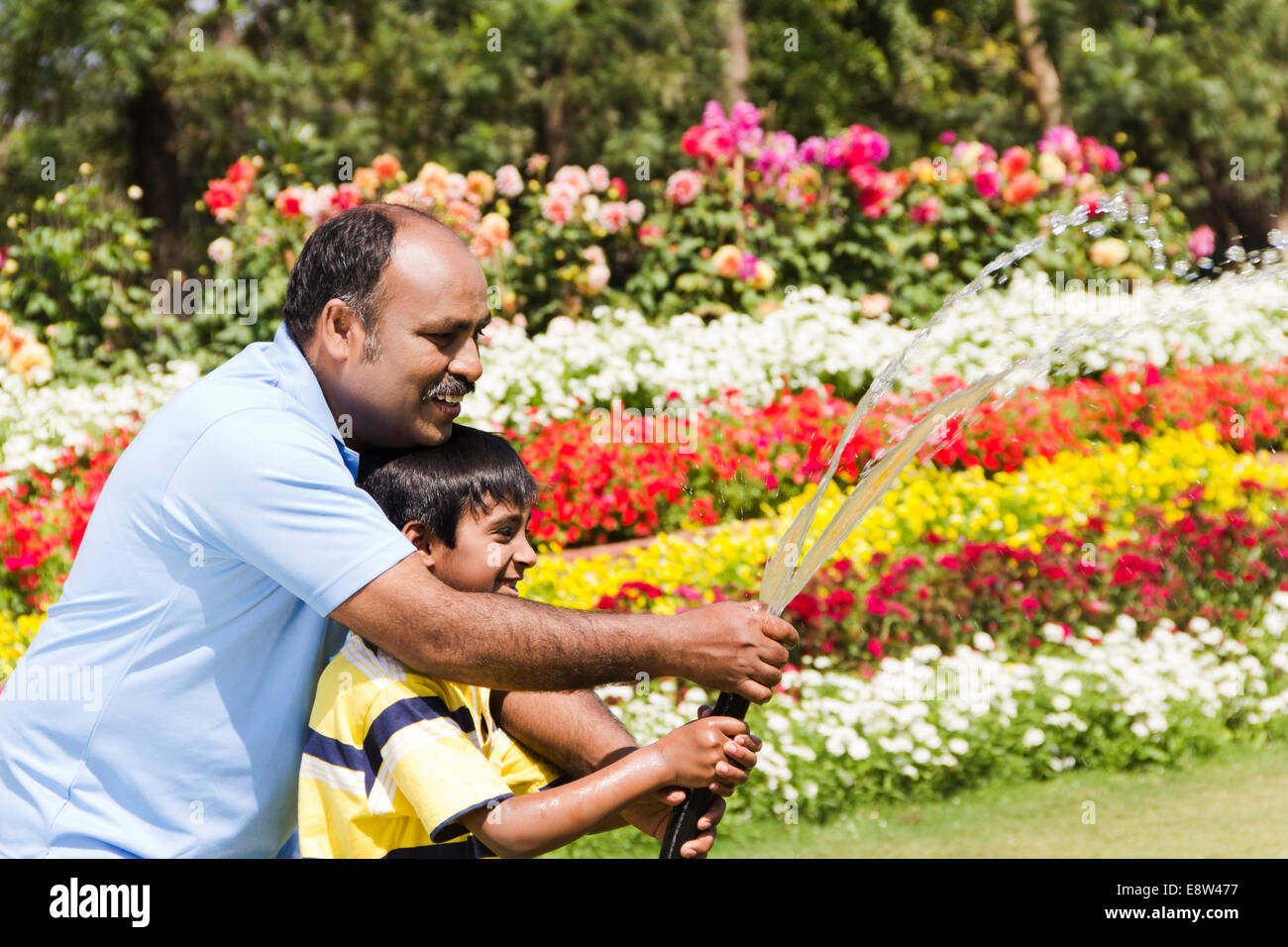 1 Indian Man Spraying Water with kid Stock Photo - Alamy