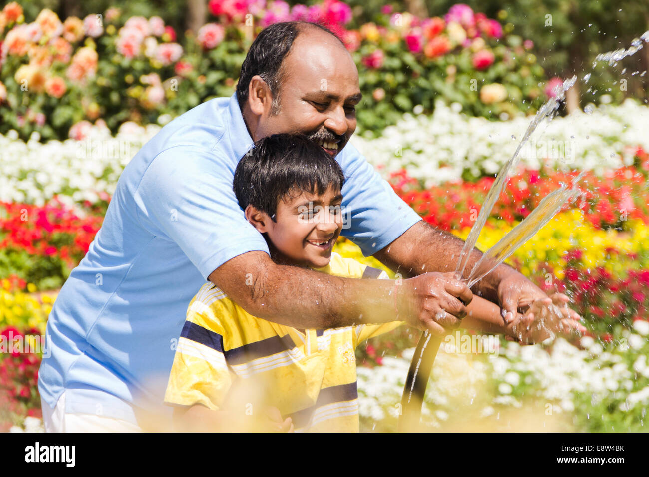 1 Indian Man Spraying Water with kid Stock Photo - Alamy