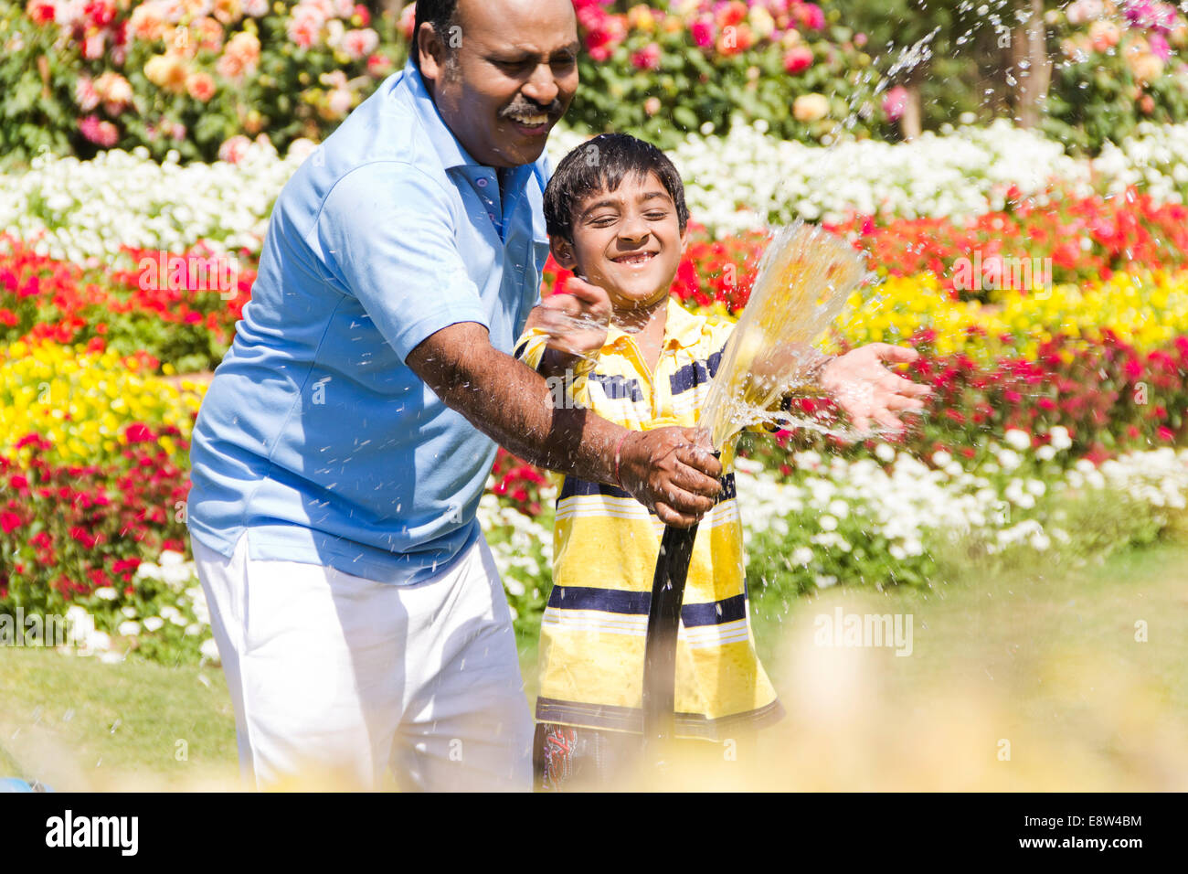 1 Indian Man Spraying Water with kid Stock Photo - Alamy