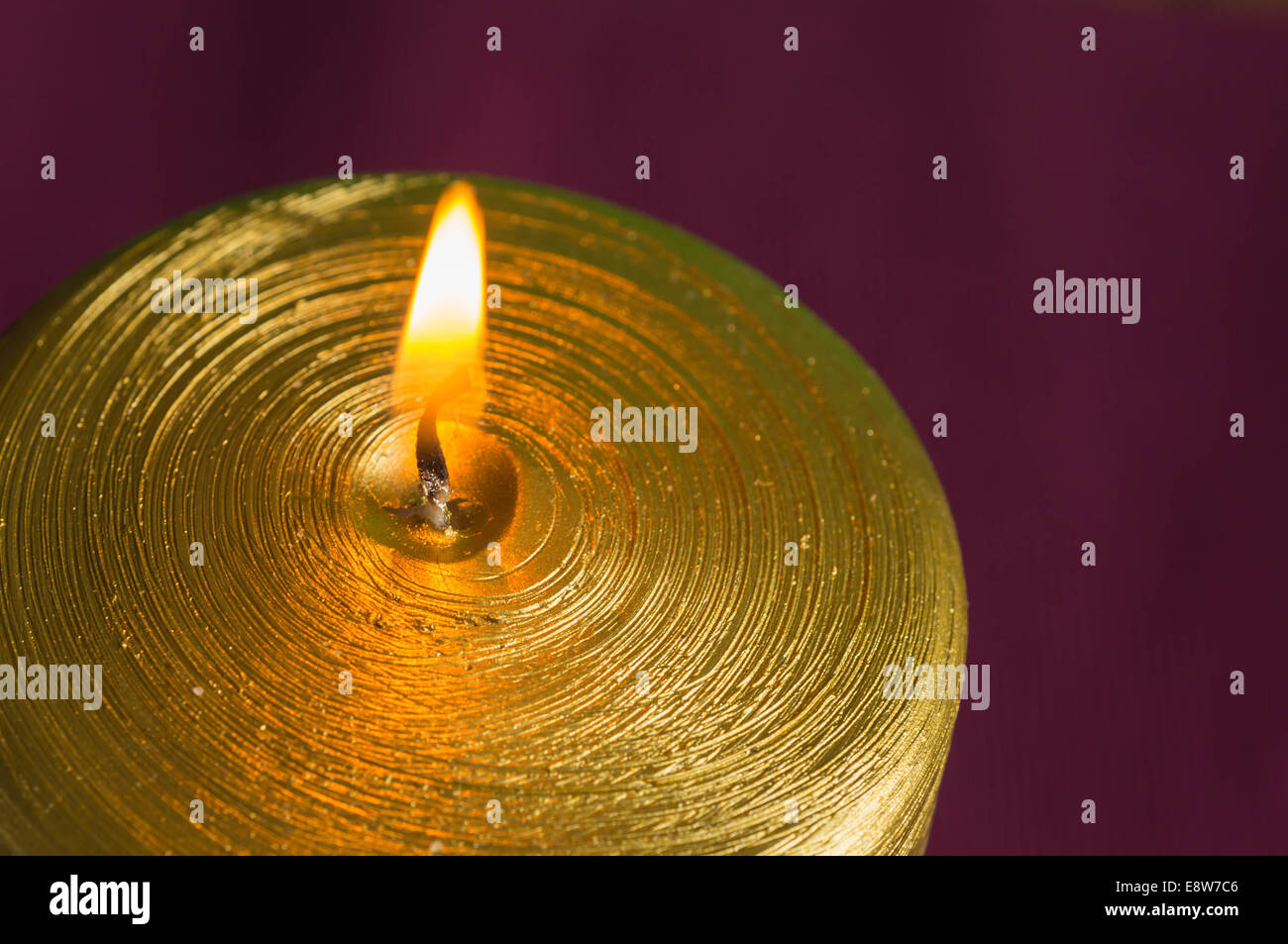 Gold candle on a claret background close up Stock Photo - Alamy
