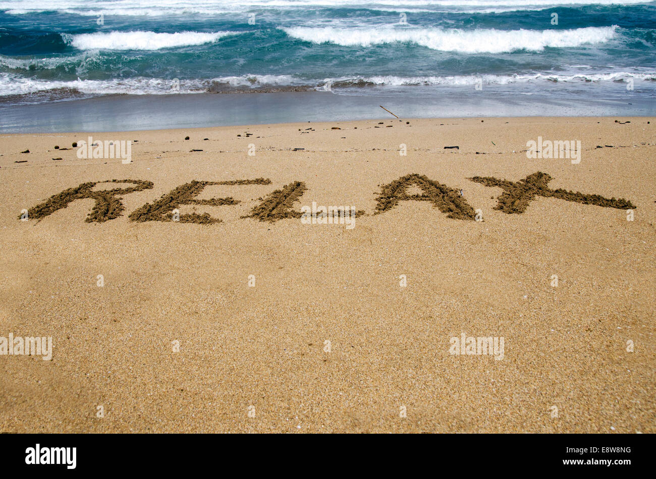 The word relax written in the sand on a beach Stock Photo - Alamy
