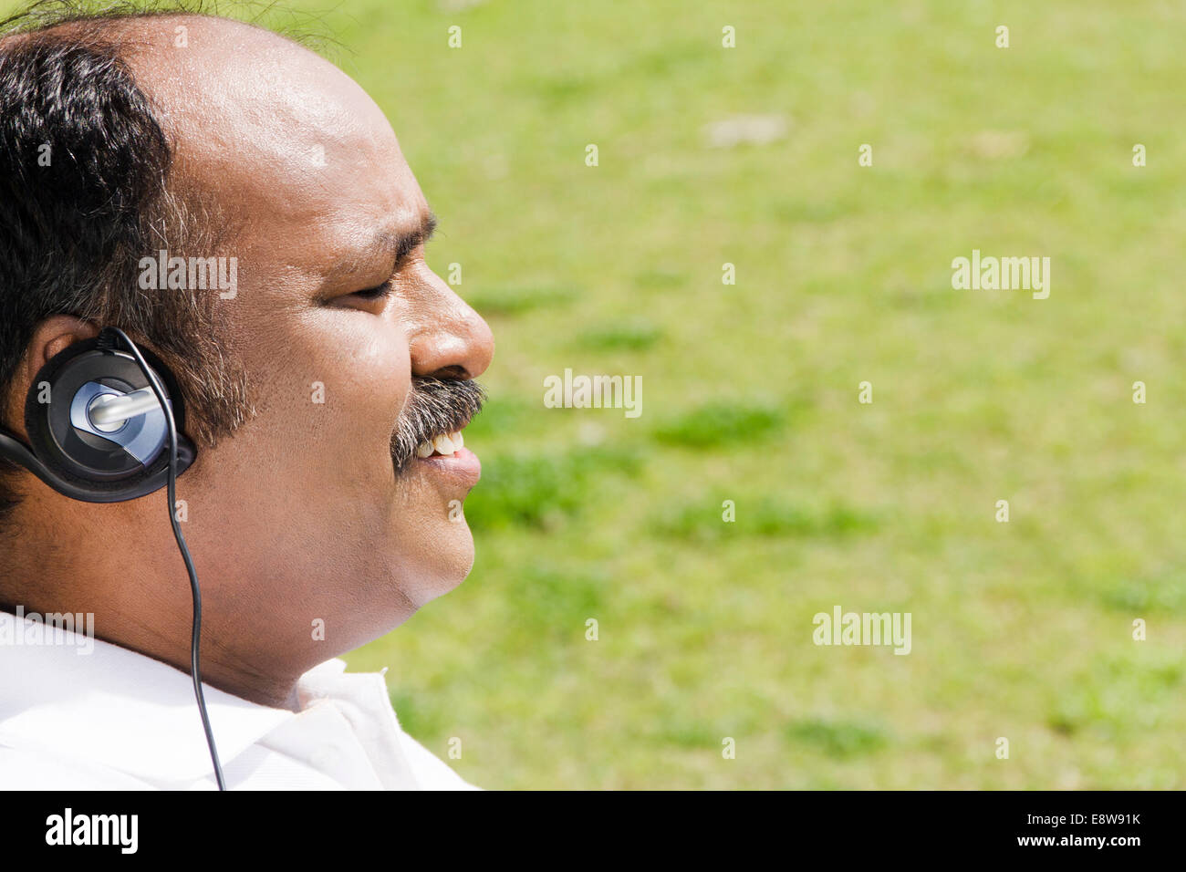 1 Indian Man Hearing Music In Park Stock Photo - Alamy