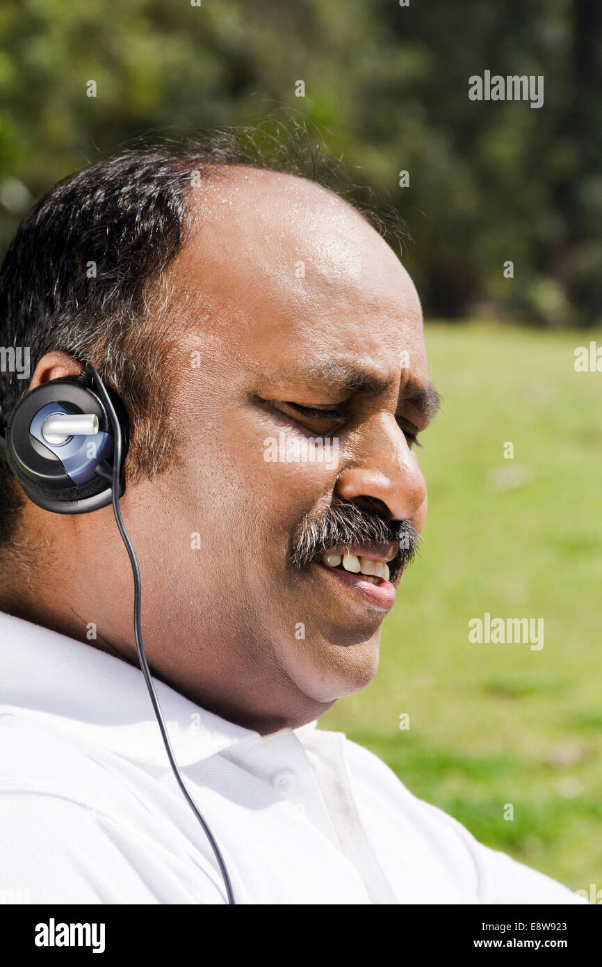 1 Indian Man Hearing Music In Park Stock Photo - Alamy