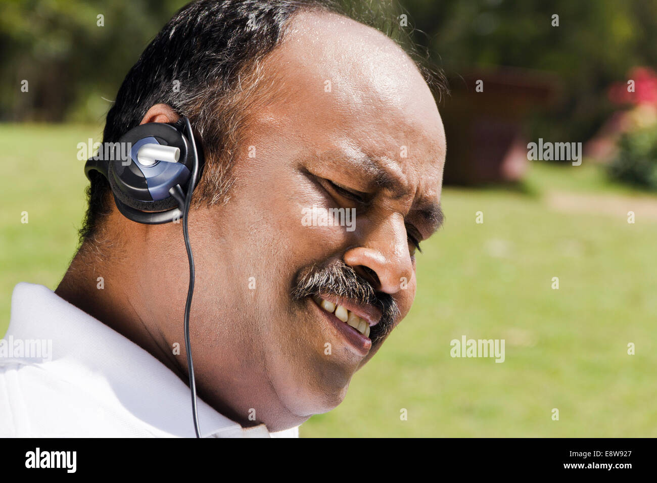 1 Indian Man Hearing Music In Park Stock Photo - Alamy