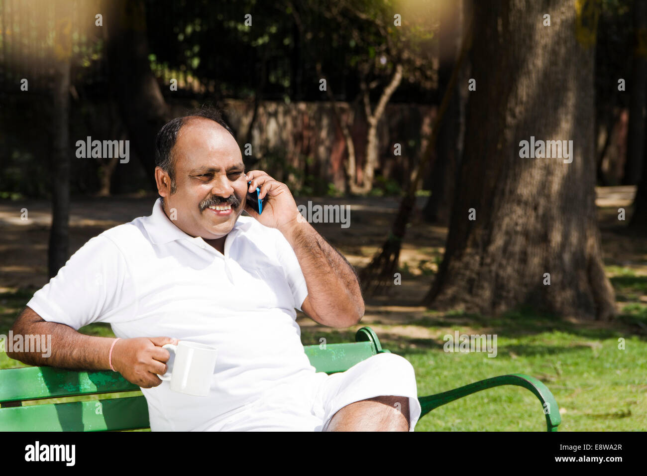 1 Indian Man Talking with Mobile in park Stock Photo - Alamy