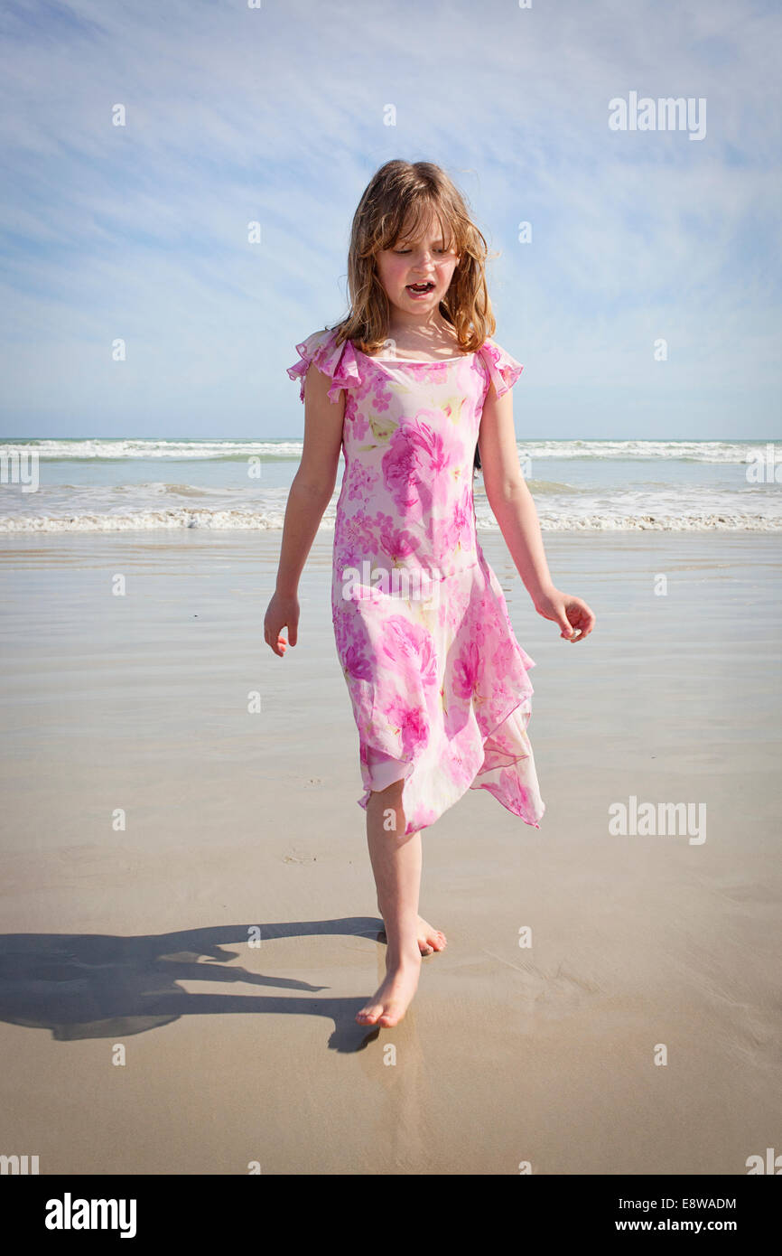 Pretty Nine Year Old Girl In A Floral Pink Dress Walking Along The Pretty Nine Year Old Girl In A Floral Pink Dress Walking Along The