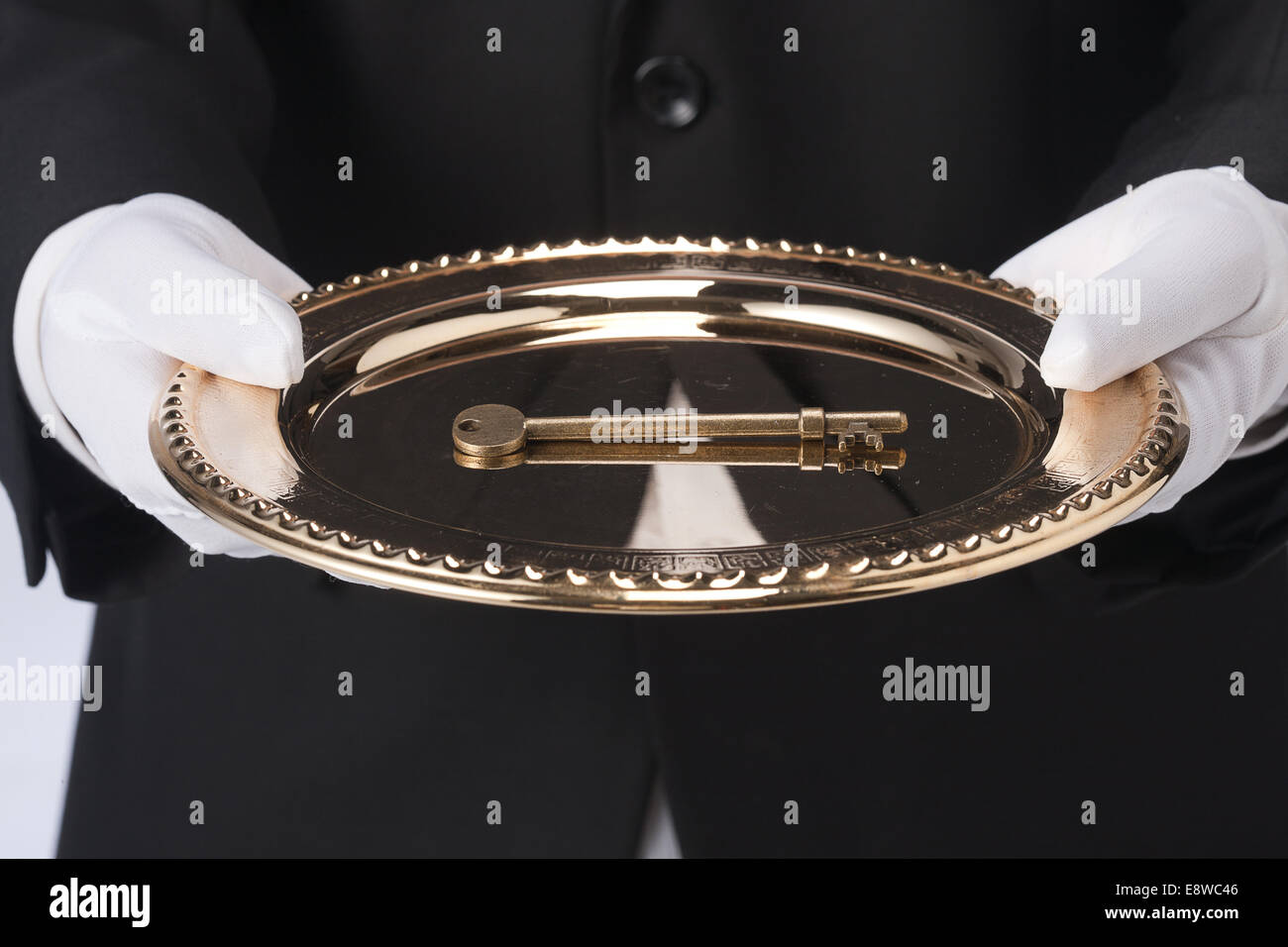Hand holding a golden key tray Stock Photo - Alamy
