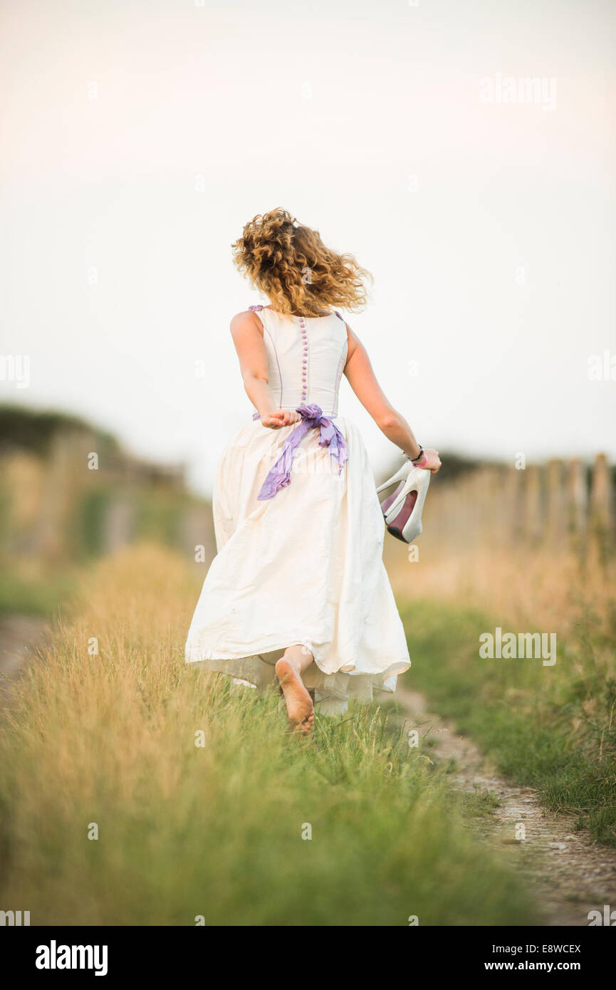 The runaway bride - a young woman girl in a wedding dress running ...