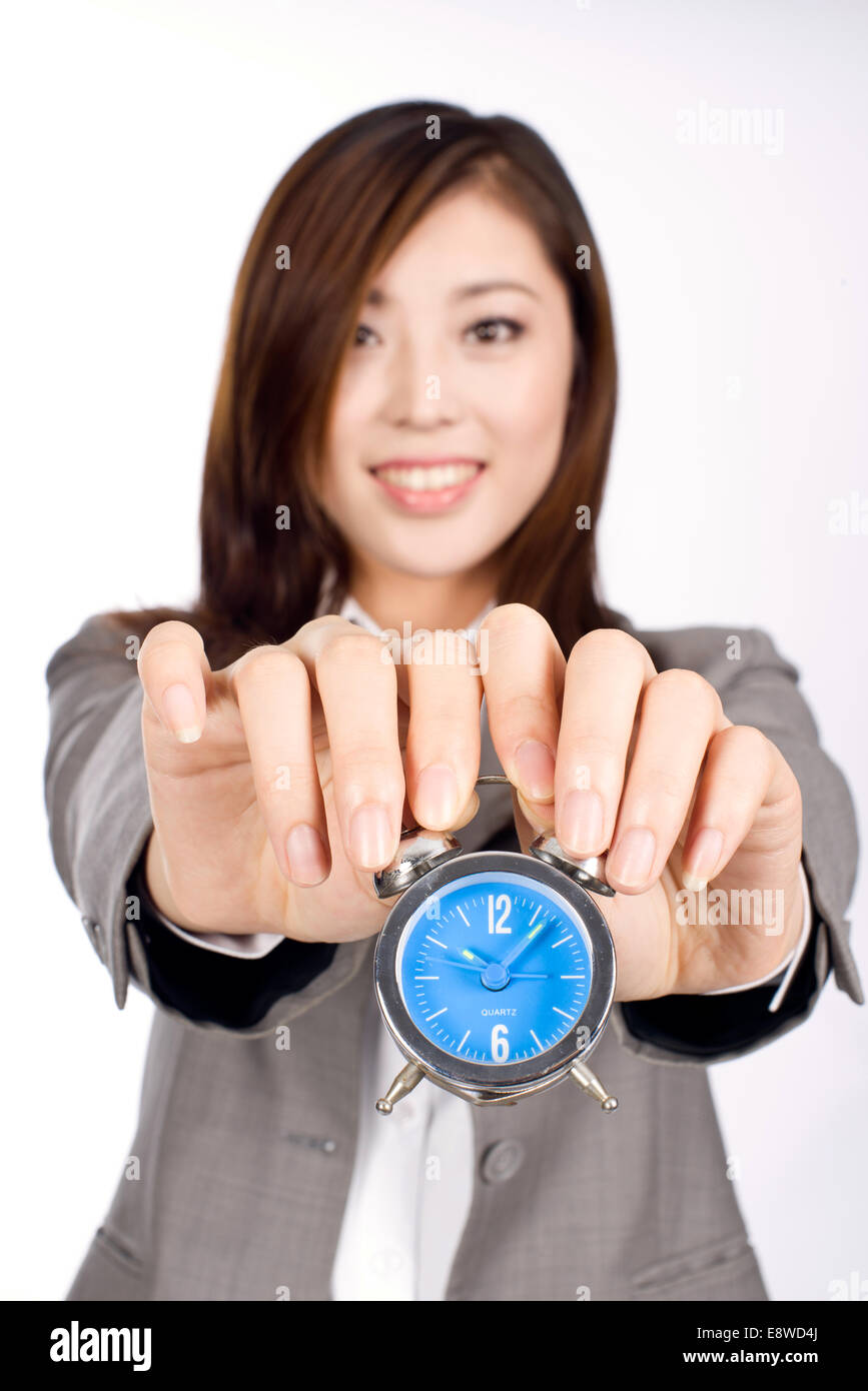 Business woman holding alarm clock Stock Photo - Alamy