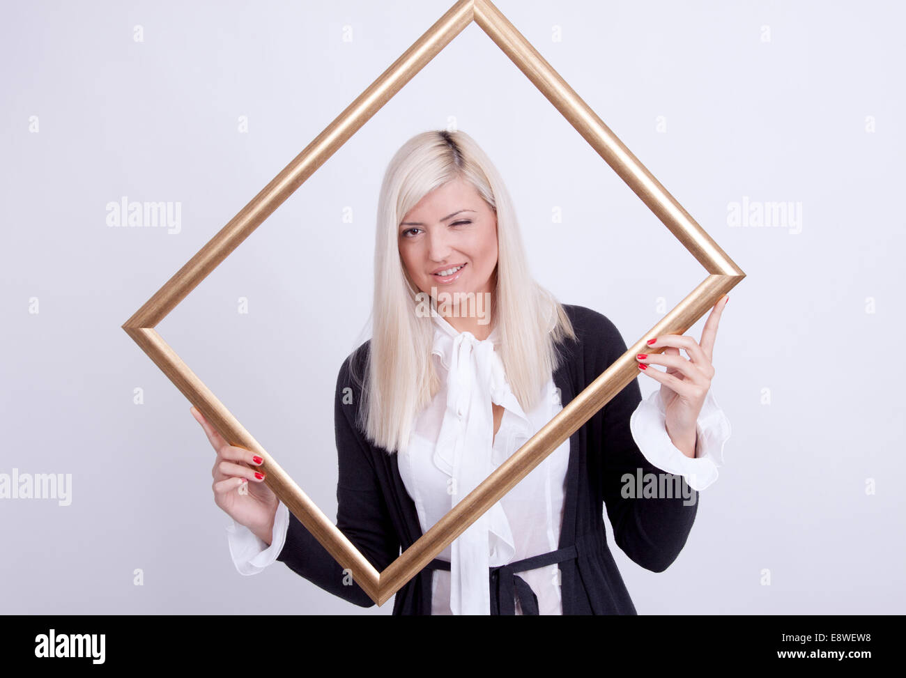 Portrait of a young blond woman holding a frame Stock Photo - Alamy