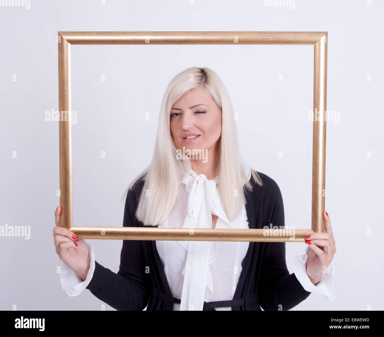 Portrait of a young blond woman holding a frame Stock Photo - Alamy