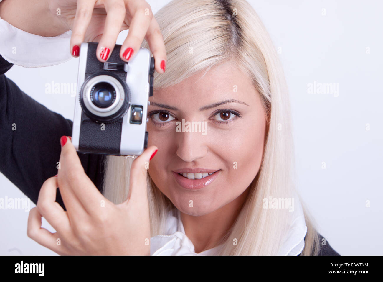 Blonde woman photographing over white background Stock Photo - Alamy