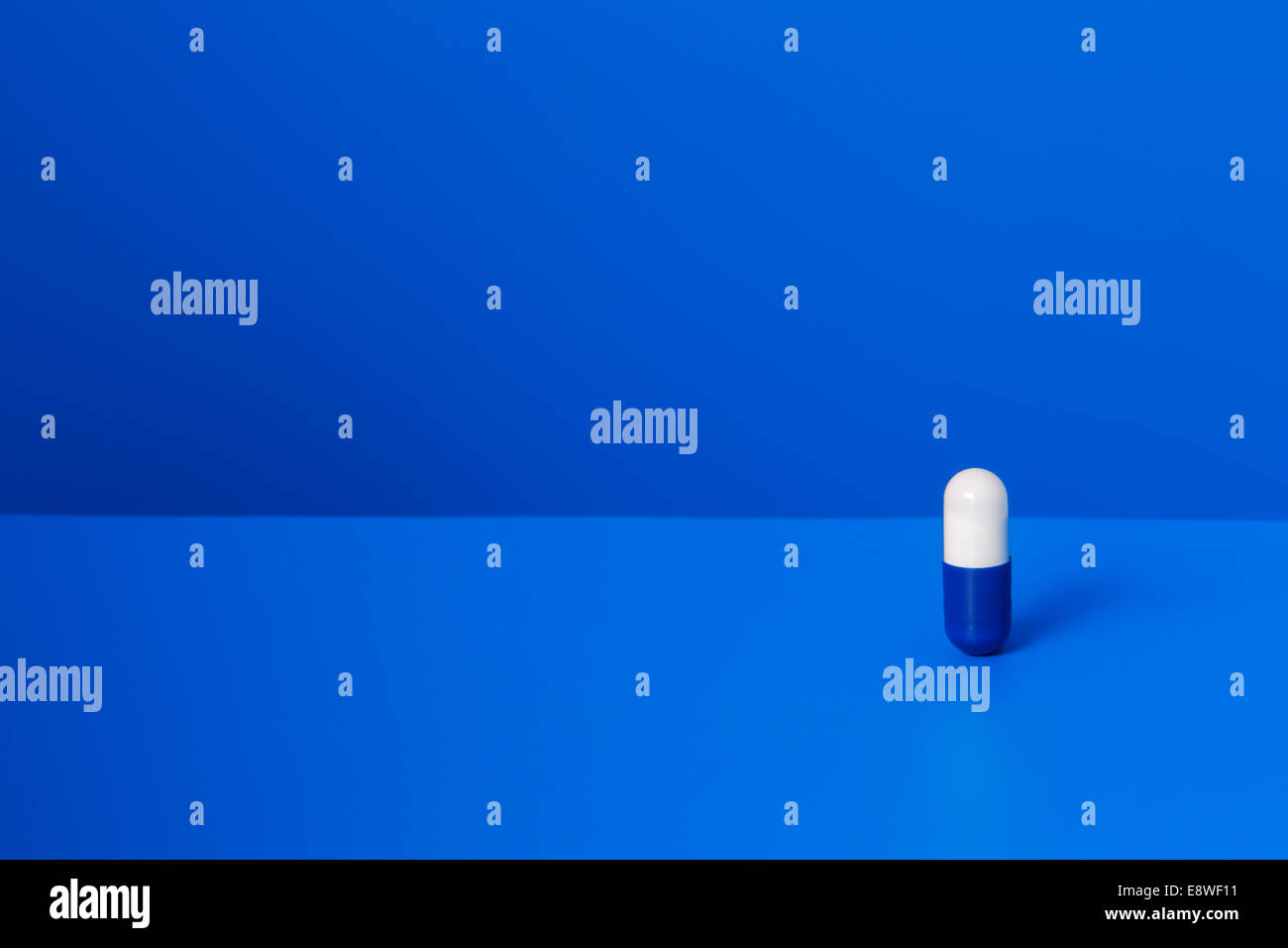 Prescription pill standing upright on blue counter Stock Photo - Alamy