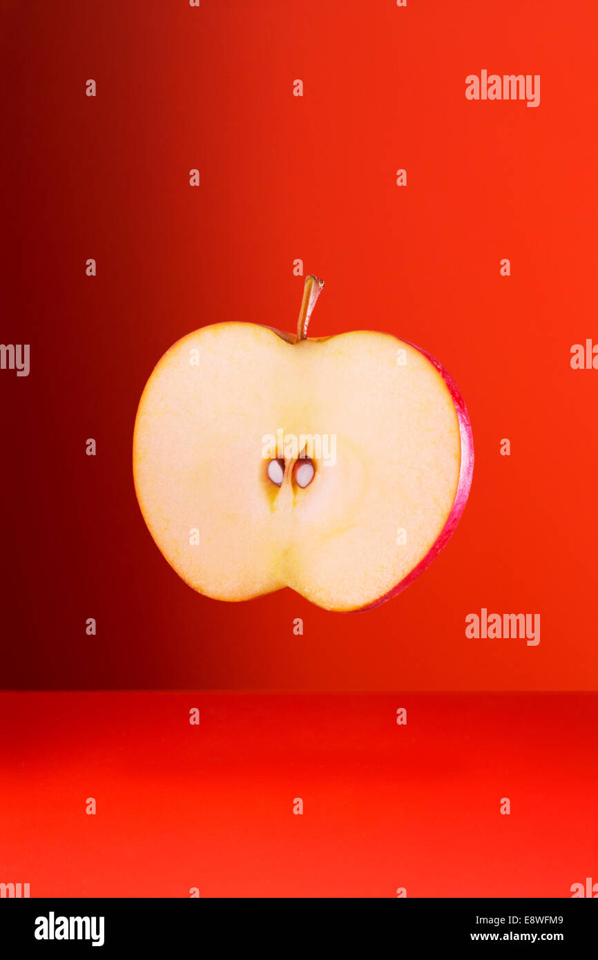 Apple slice on red counter Stock Photo - Alamy