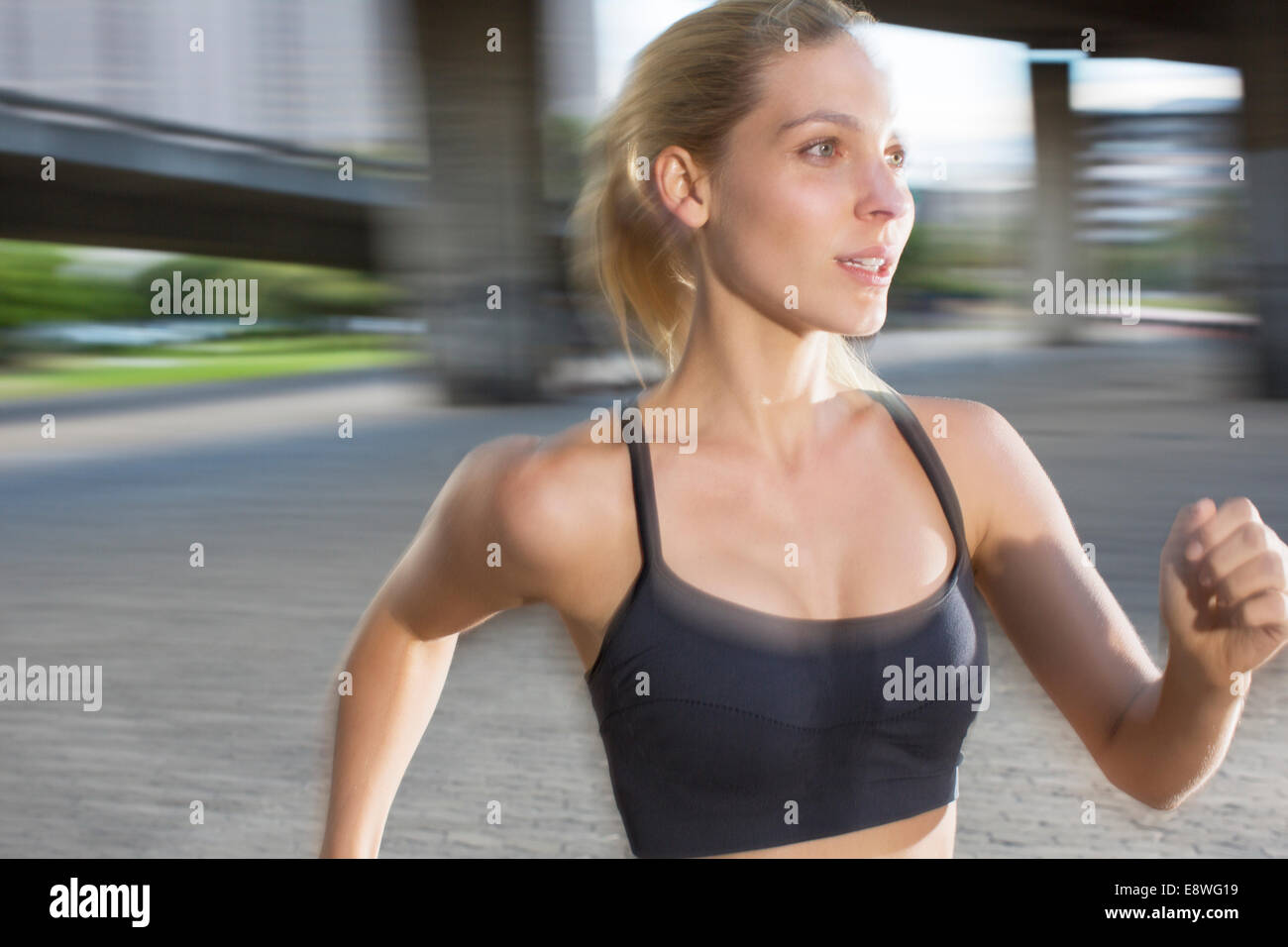 Woman running through city streets Stock Photo - Alamy