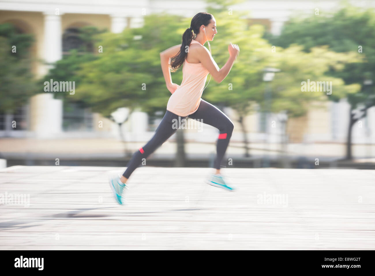 Woman running through city streets Stock Photo - Alamy