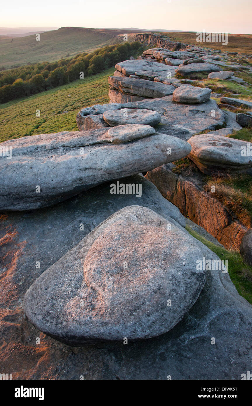 Warm summer sunset glow on rocks at Stanage edge in the Peak District ...