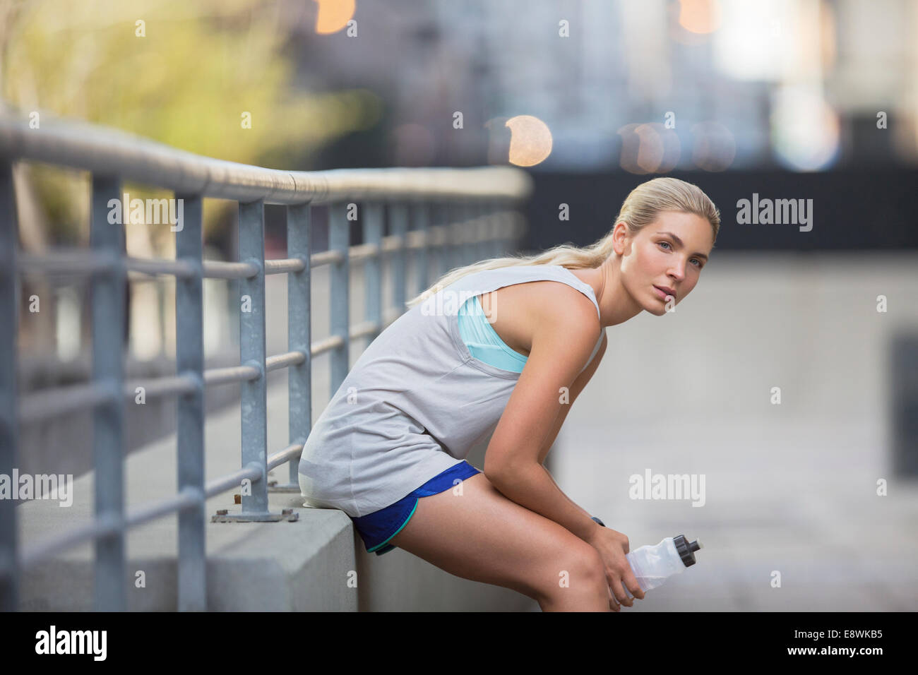 Woman resting after exercising on city street Stock Photo - Alamy