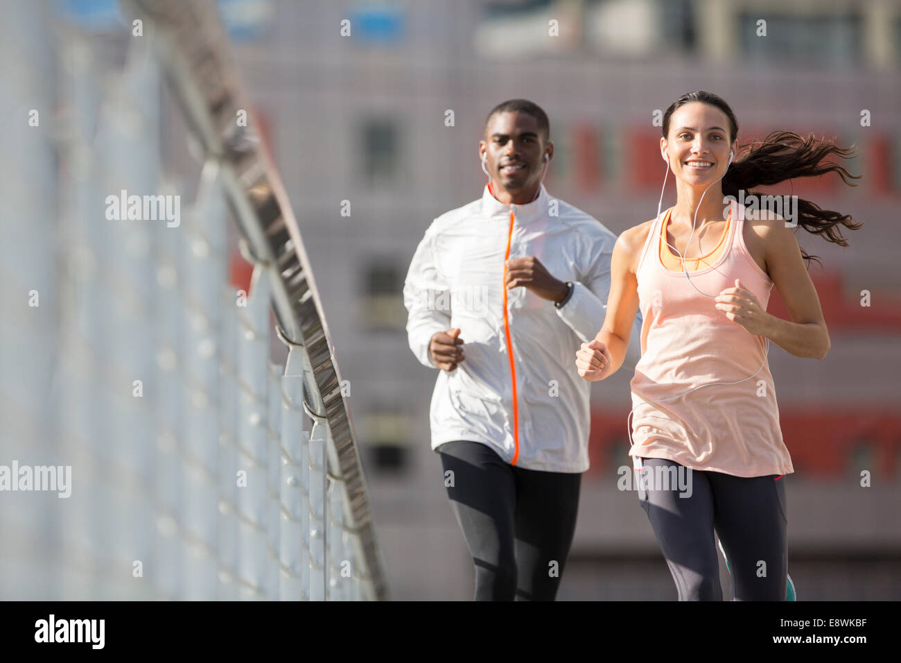 Friends running through city streets together Stock Photo - Alamy